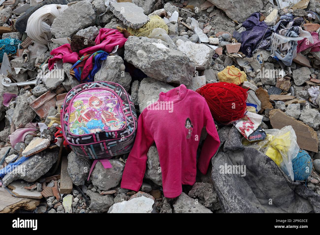 A little girl's school bag, clothes, and red yarn used by her mother to ...