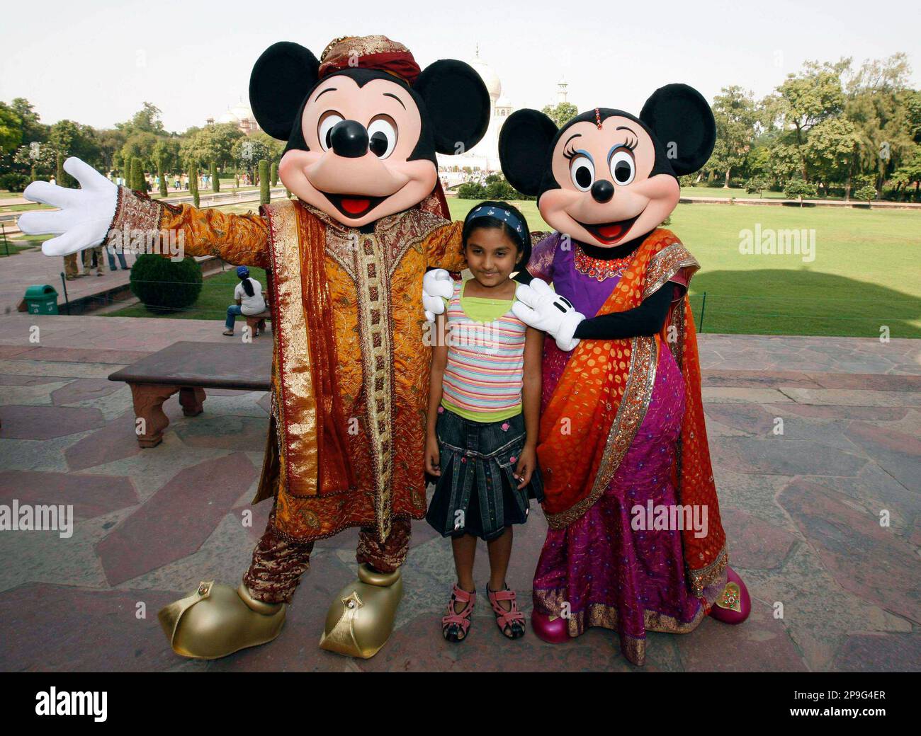 Walt Disney's Mickey Mouse, left, and Minnie Mouse pose with a child at ...