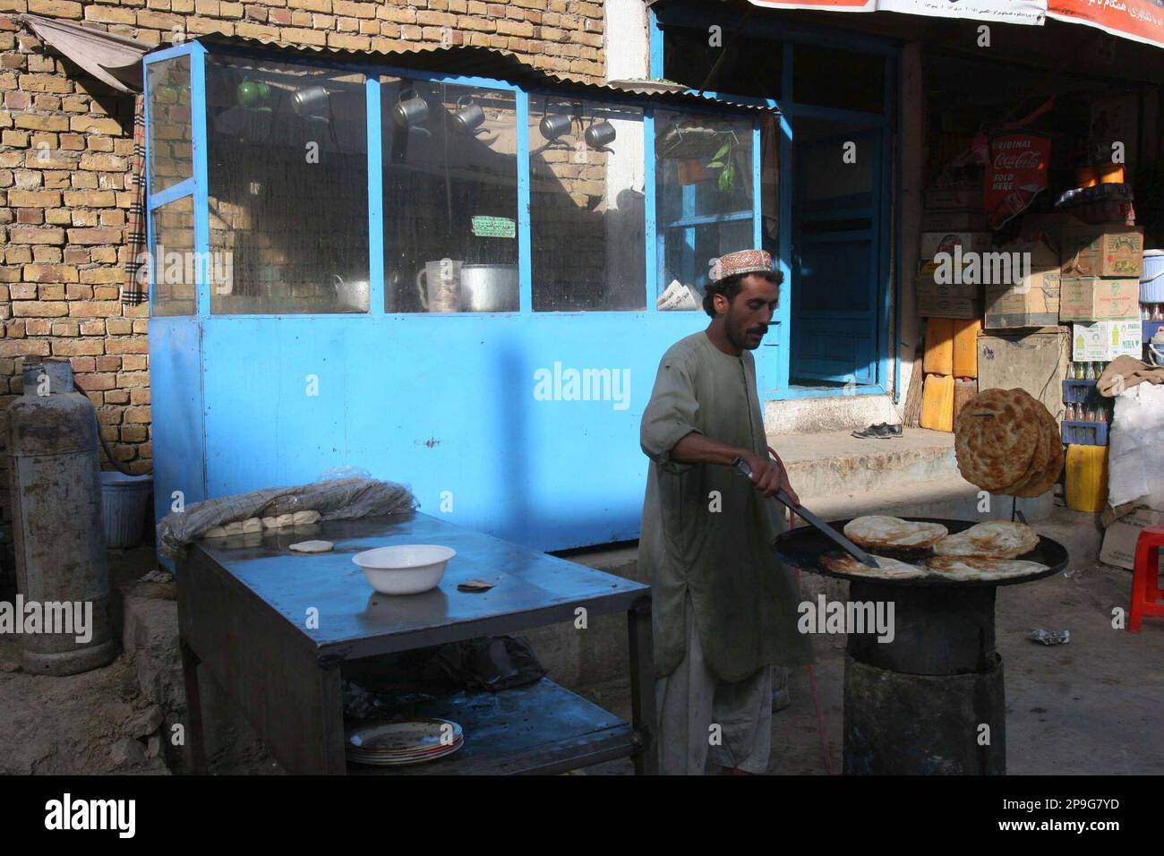 An Afghan street vendor bakes Afghani bread in the city of Kandahar ...