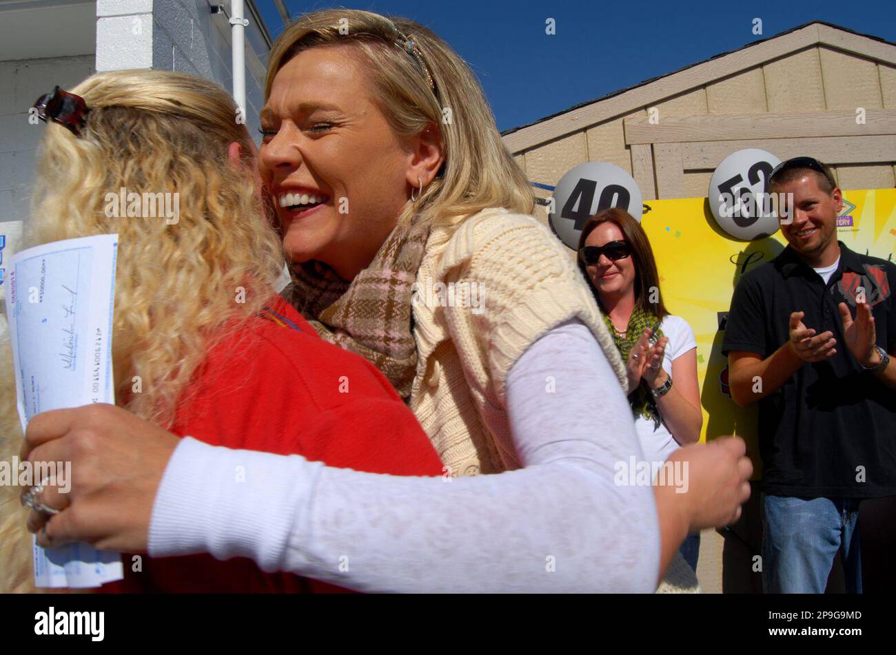 Lottery winner Holly Baldwin, right, hugs Leandra Torres, Assistant ...