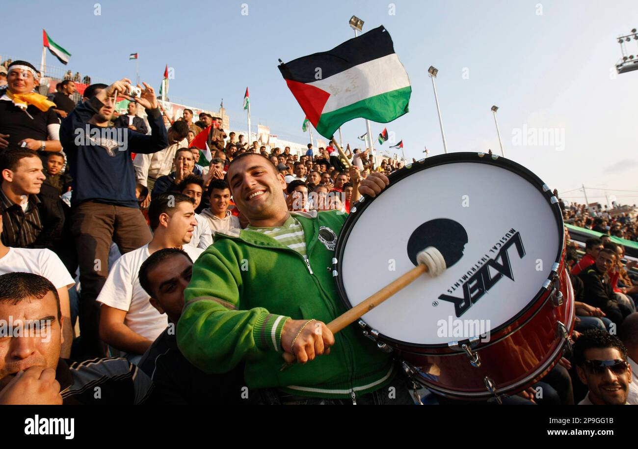 Palestinian soccer fans are seen prior to a soccer match between the ...