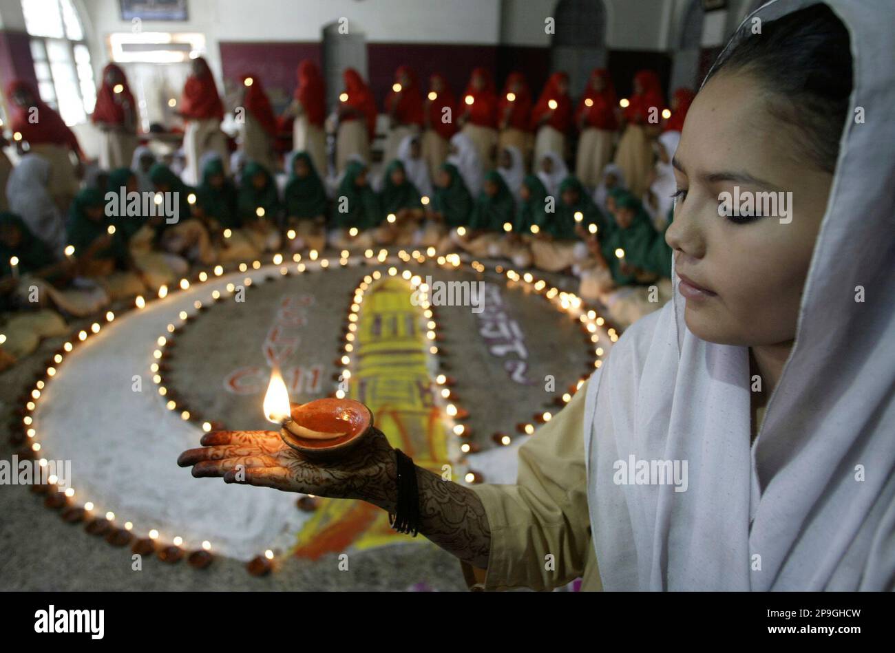 Muslim students hold candles as they jointly celebrate the success of ...