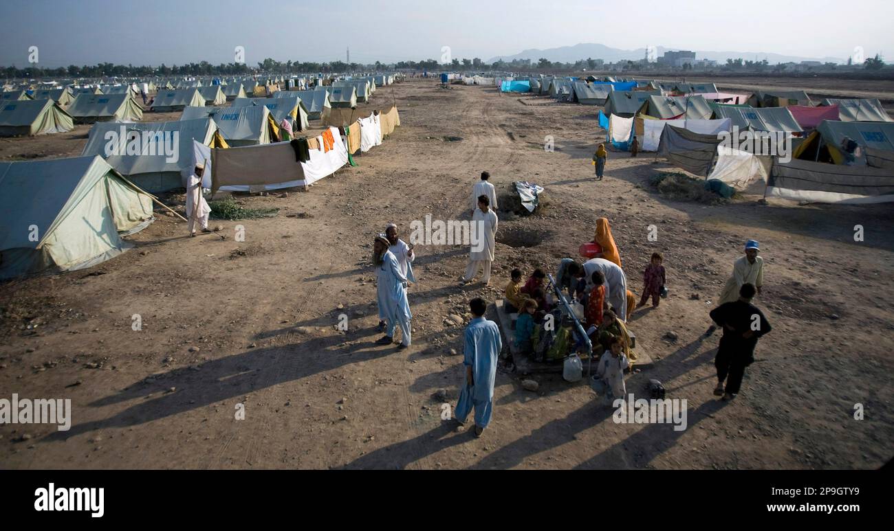 Pakistani people from the Bajur tribal region collect water from a ...
