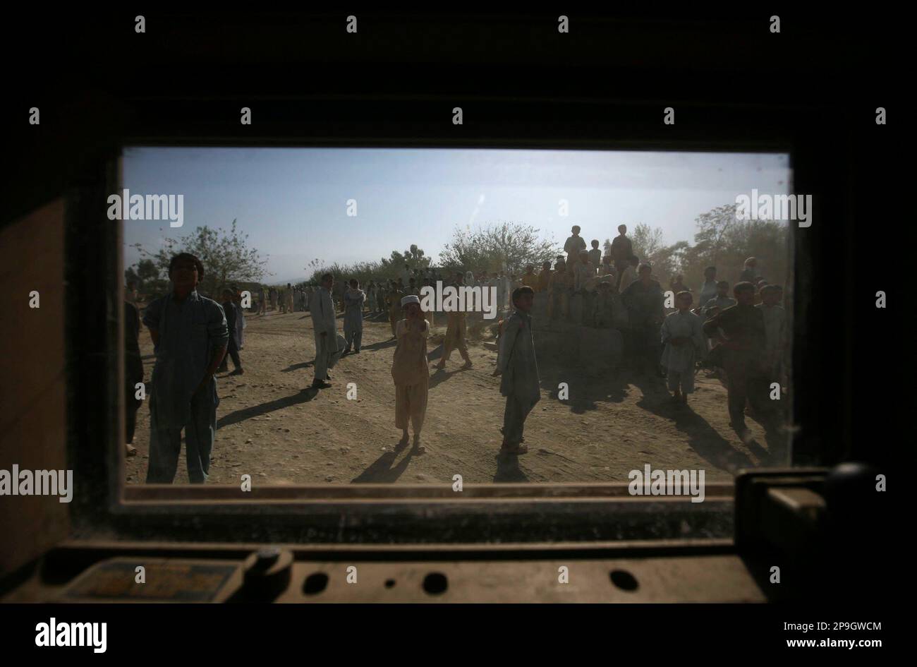 Afghans are seen through the window of a U.S. army vehicle, during a ...