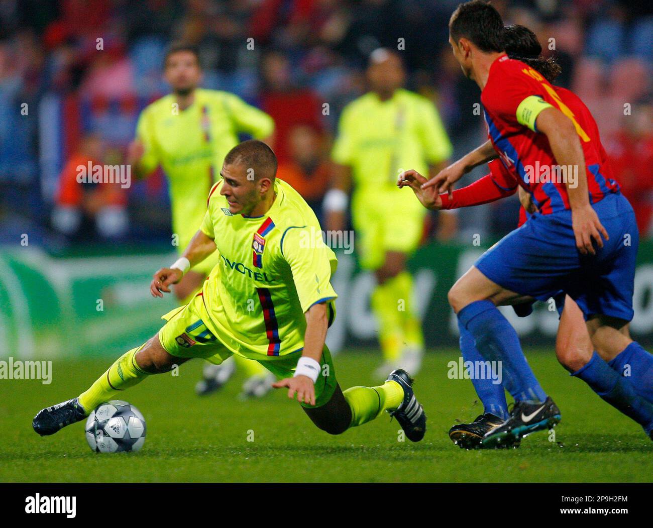 Lyon's Karim Benzema, left, falls tackle by Steaua Bucharest's Mirel ...