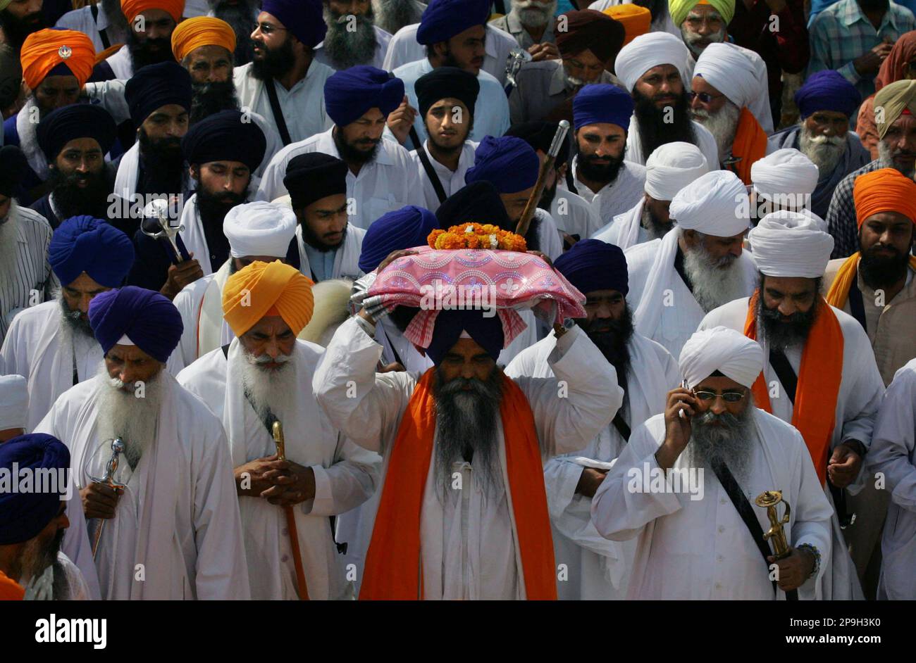 A Sikh priest carries Sri Guru Granth Sahib, the Sikh Holy Scripture ...