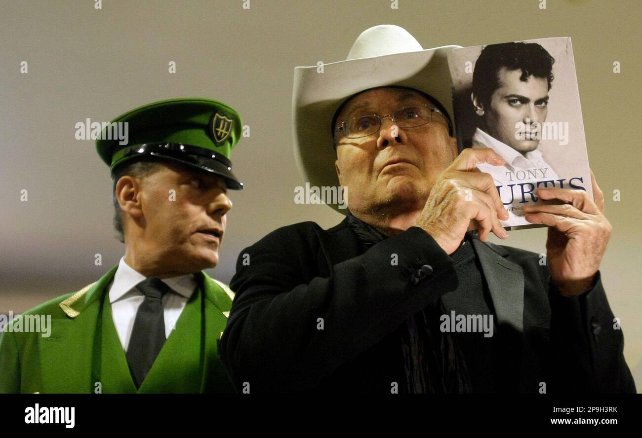 US actor Tony Curtis, right, poses for photographs before signing ...