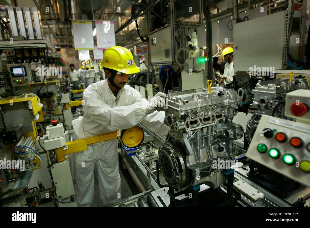 A worker shifts a semi complete engine at the assembly line of the ...