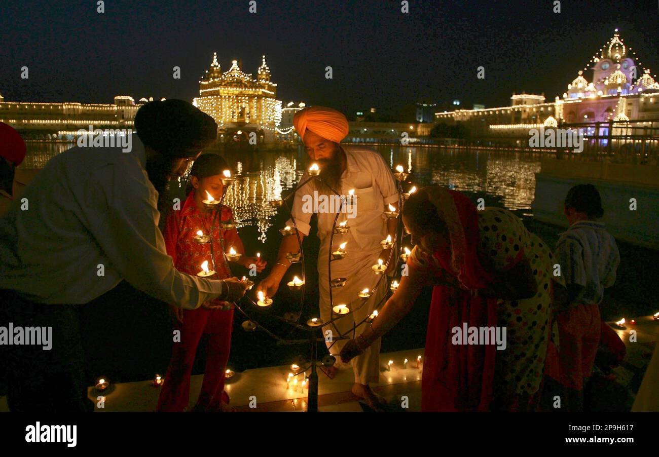 Sikh devotees light lamps in the backdrop of the Golden Temple, Sikh’s ...