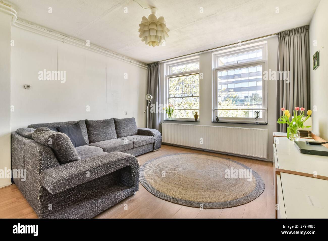 a living room with a couch and rug on the floor in front of a large ...