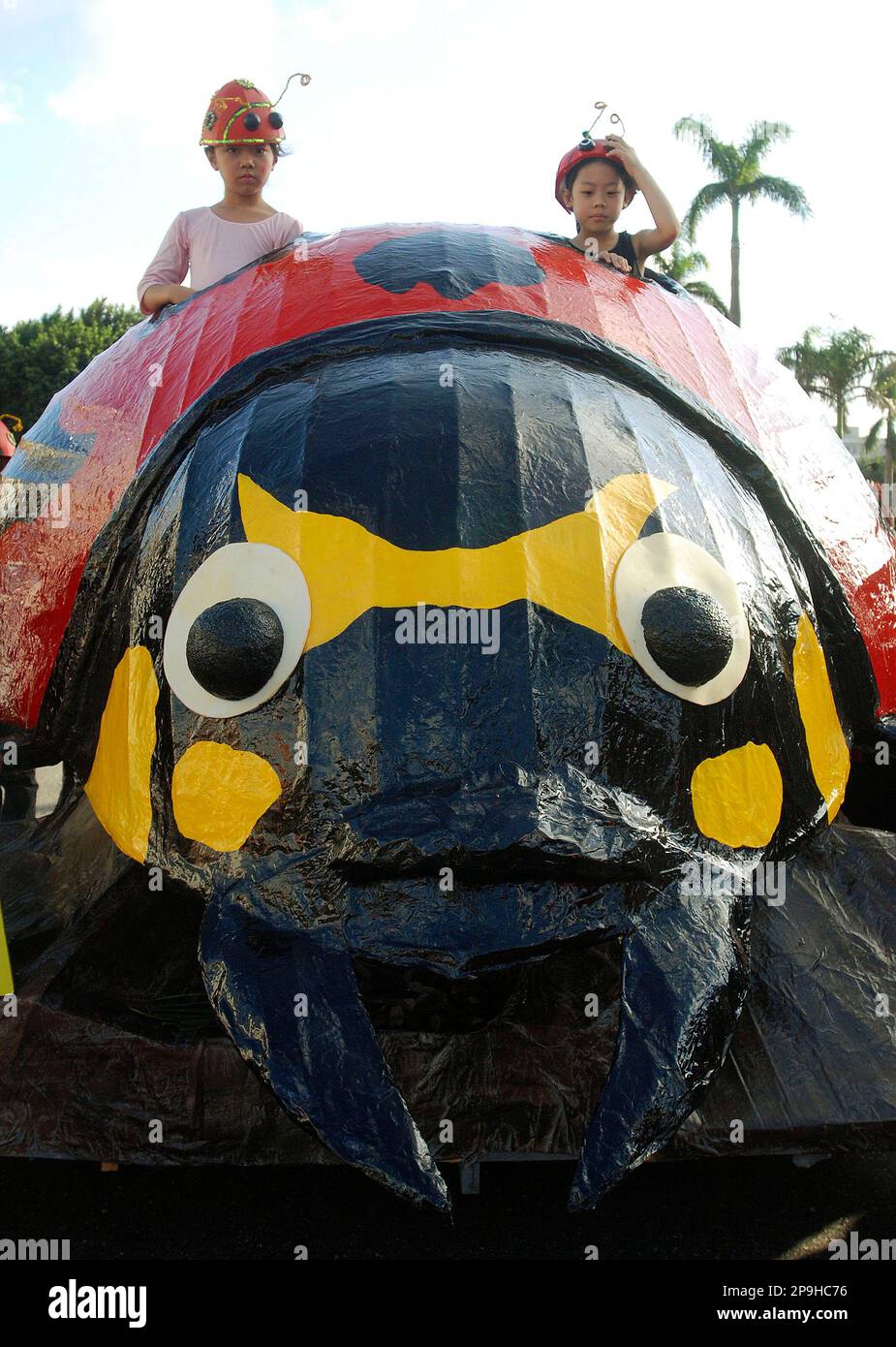Taiwanese children wear a variety of costumes and sit on a huge ladybug ...