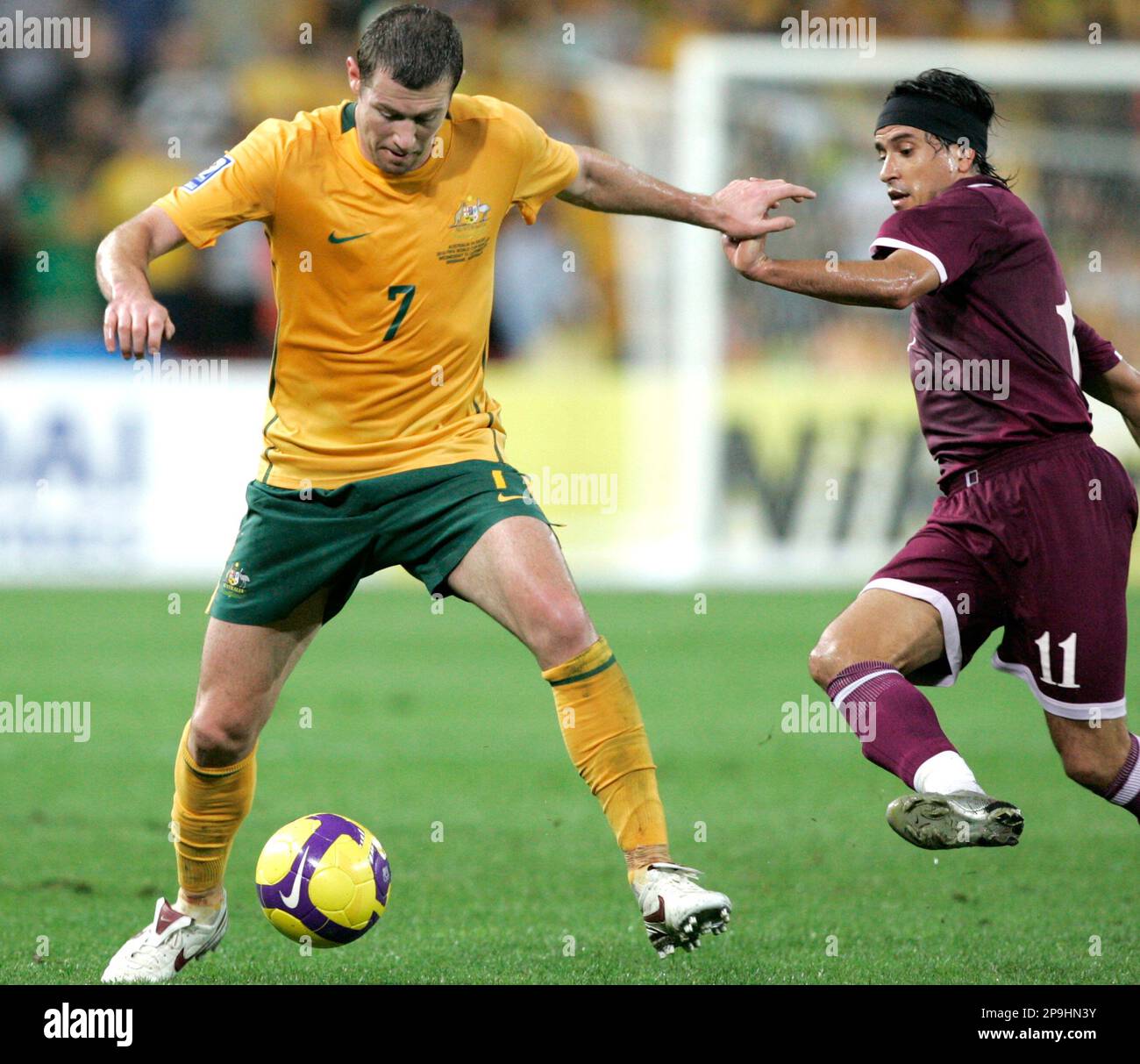 Australia's Brett Emerton, left, and Qatar's Faboi Montesin in action ...