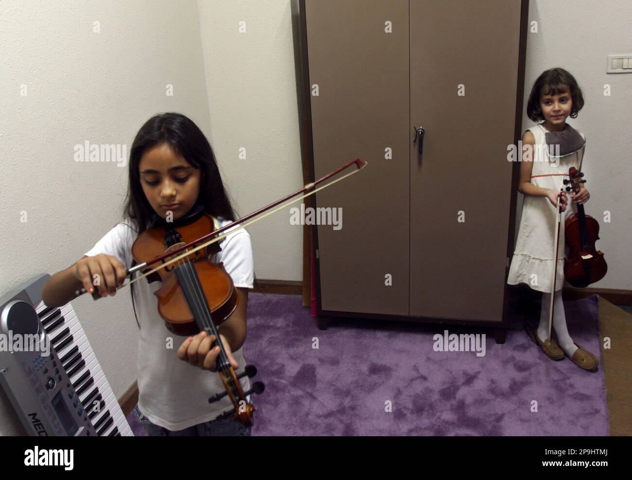 A Palestinian girl plays the violin, during a lesson at the Gaza Music ...