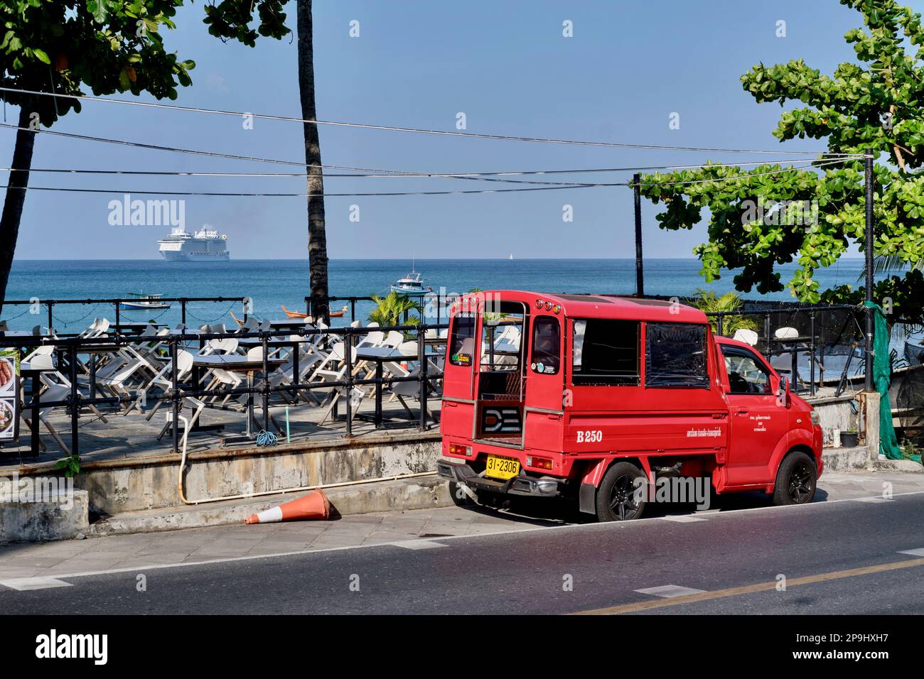A red songthaew ('two rows'), a local type of taxi, parked on the main ...