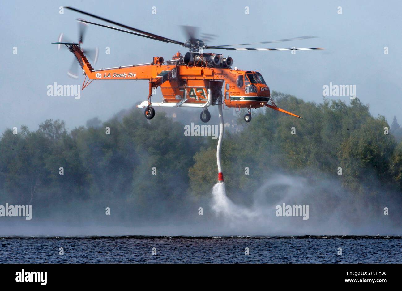 A water-dumping helicopter fills up at Hansen Dam on Sunday, Oct. 12 ...