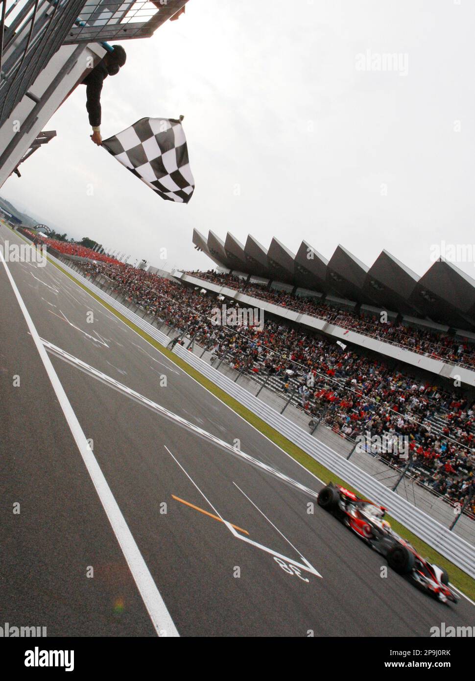 McLaren driver Lewis Hamilton crosses the finish line to finish twelfth ...