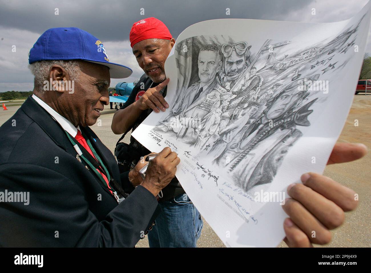 Tuskegee Airman Eugene Henry signs a poster for Eric Moore at the ...