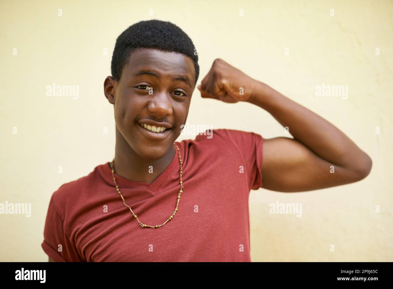 Watcha think. Portrait of a teenage boy showing off his muscles while ...