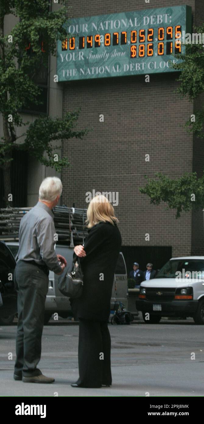 Passerbys stop to read the current amount of the U.S. national debt as ...