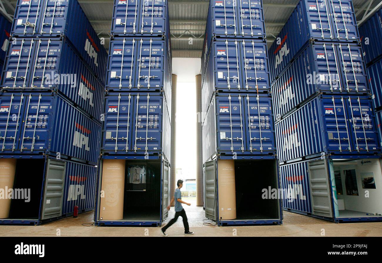 A man walks past stacked containers as part of an art installation ...
