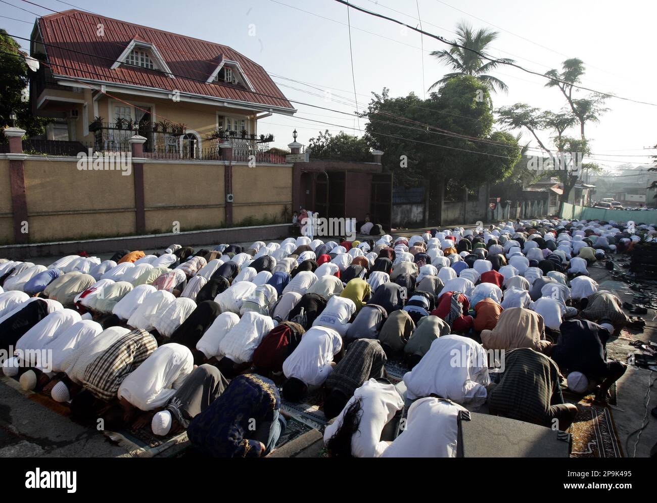 Filipino Muslims pray along a street near the Blue Mosque at Manila's ...