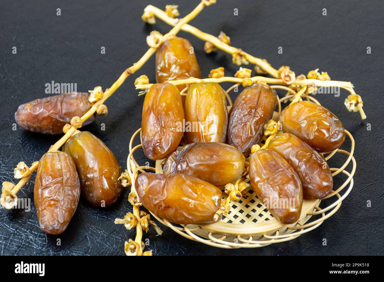 Close-up of Algerian royal dates on a wooden plate on a black ...