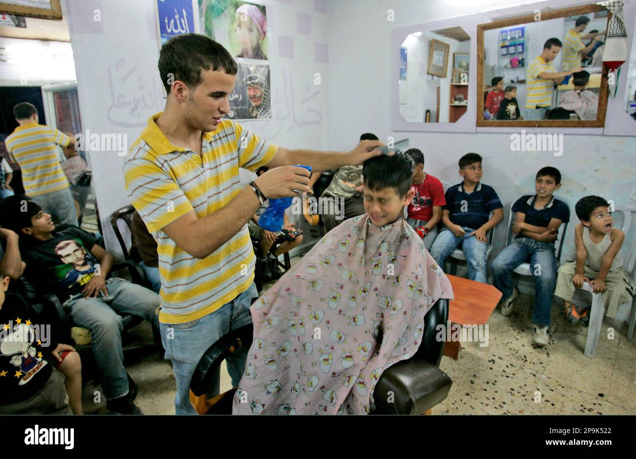 A Palestinian Muslim boy gets a hair cut at a barber shop celebrating ...