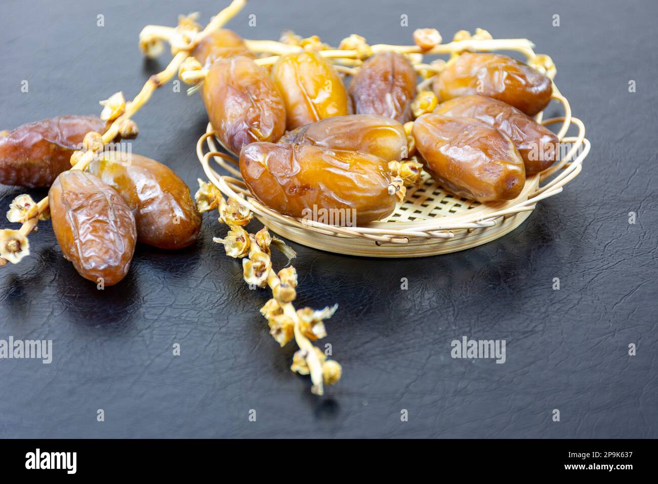 Close-up of Algerian royal dates on a wooden plate on a black ...