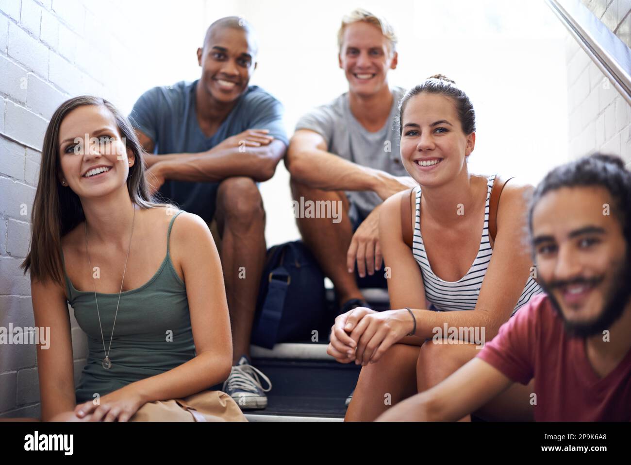 Relaxing in the stairwell before class. university students sitting on ...