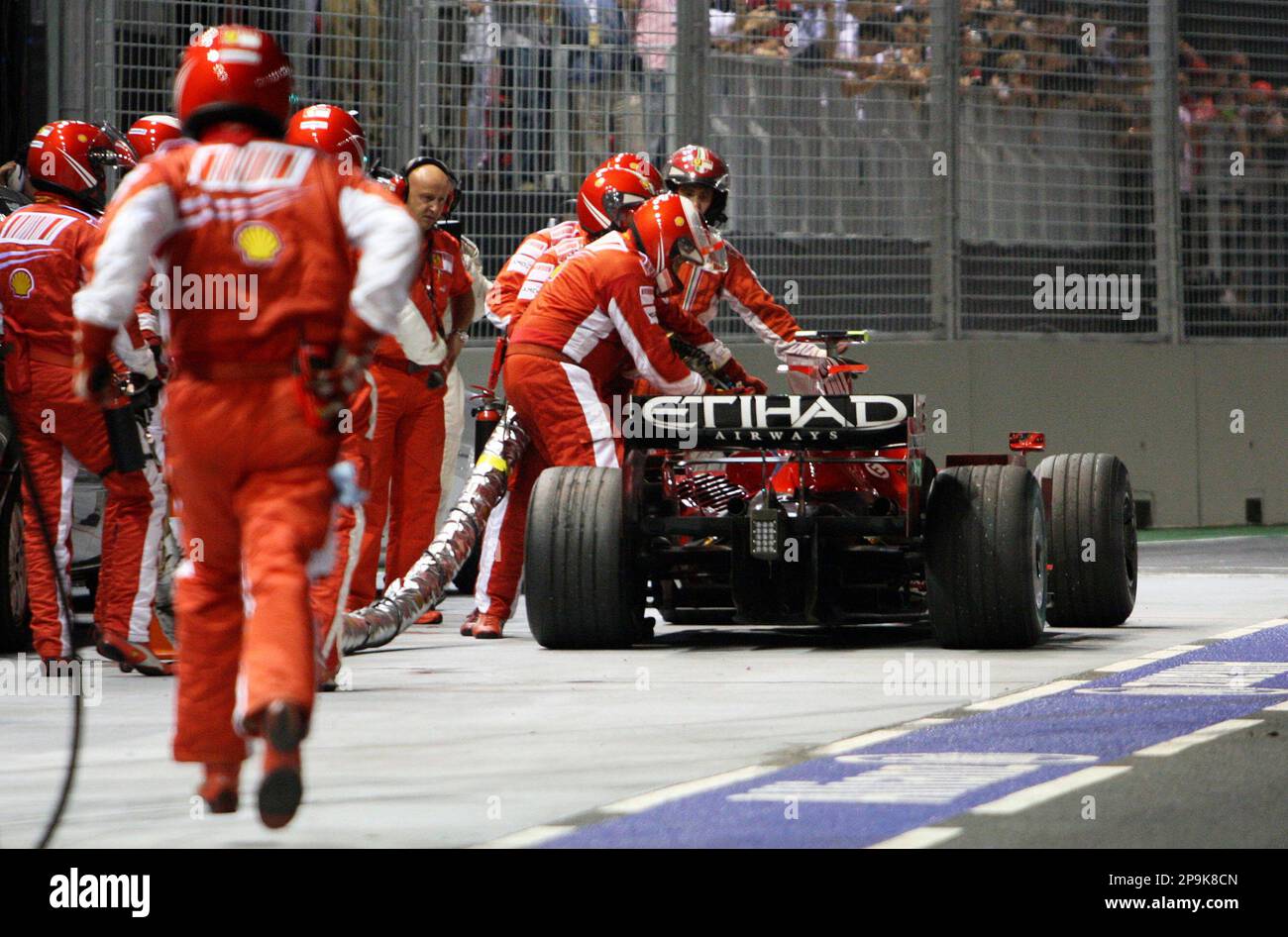 The Ferrari pit crew fail to get the fuel hose out of the car of ...
