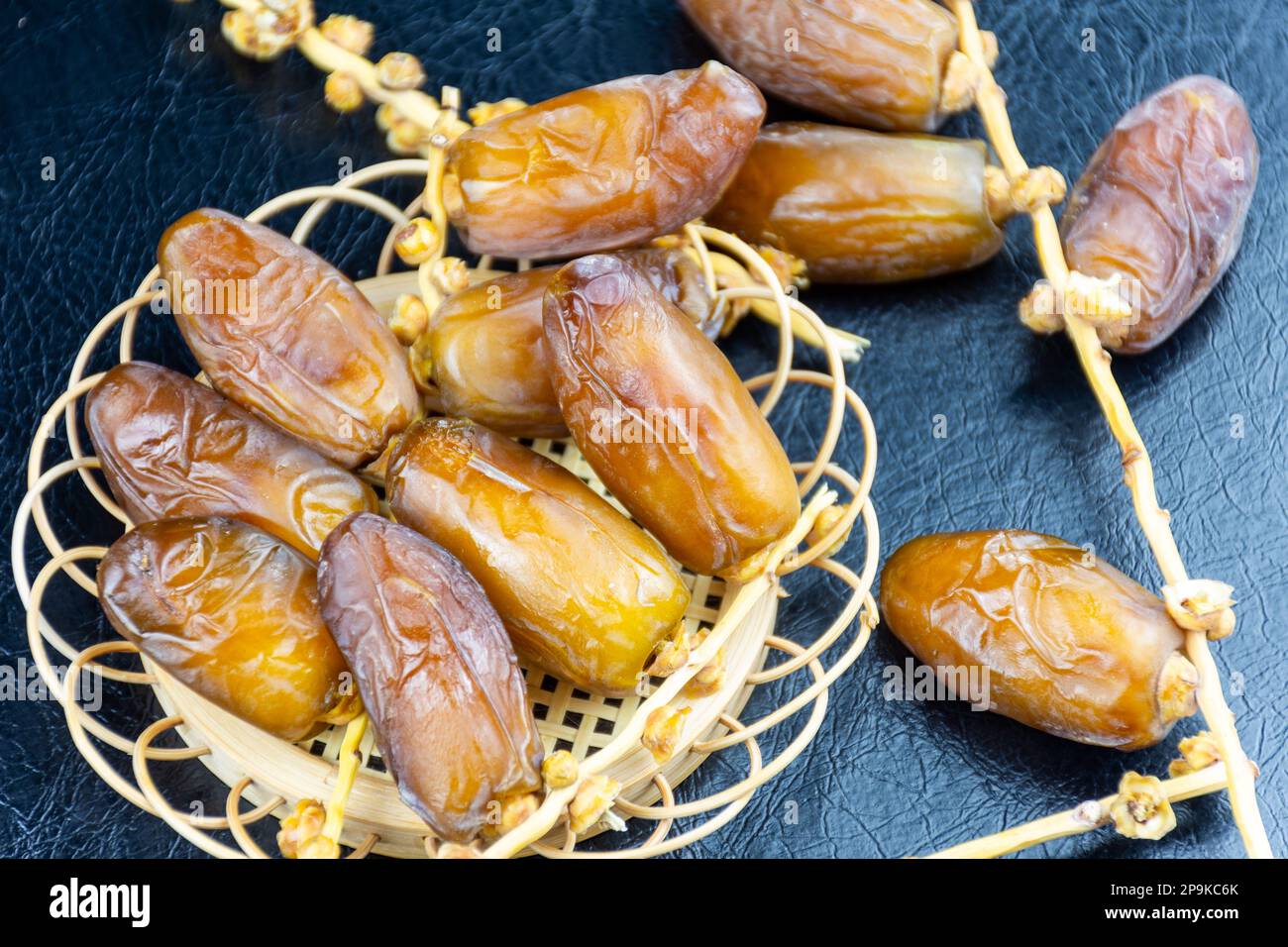 Close-up of Algerian royal dates on a wooden plate on a black ...