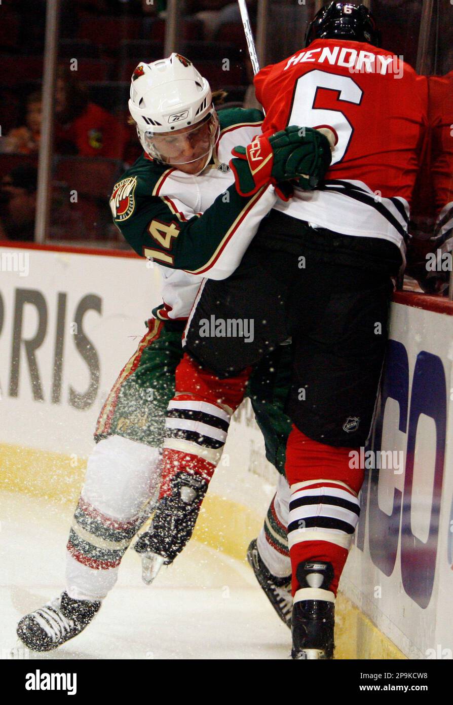 Chicago Blackhawks' Jordan Hendry, right, is checked by Minnesota Wild ...