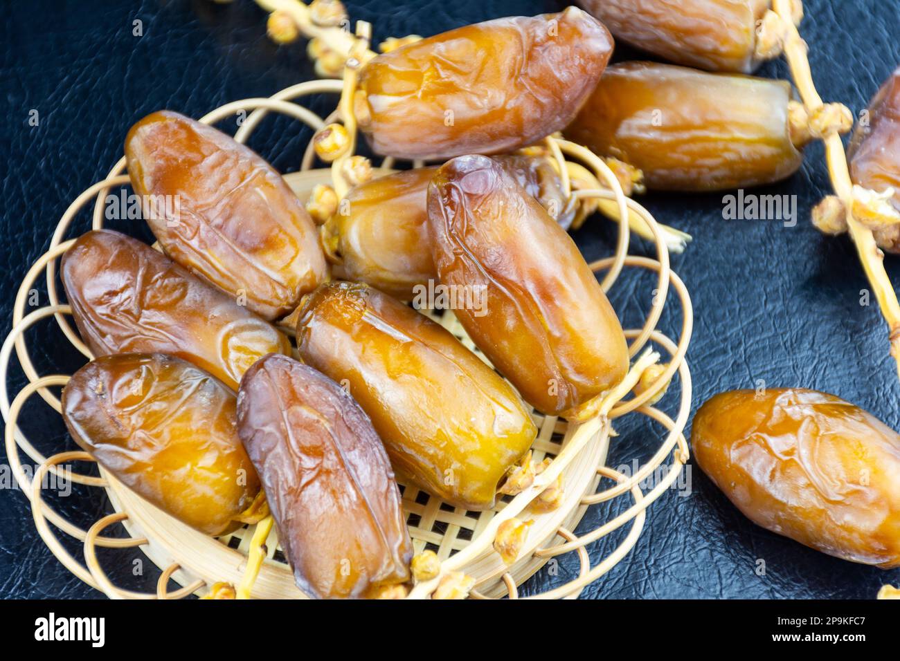Close-up of Algerian royal dates on a wooden plate on a black ...