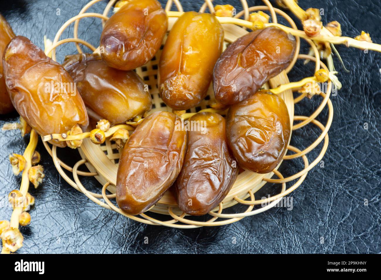 Close-up of Algerian royal dates on a wooden plate on a black ...