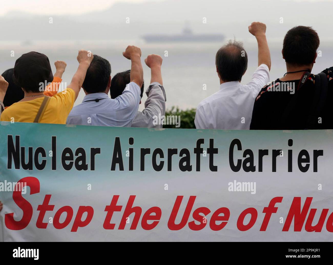 Protesters shout a slogan against U.S. Navy nuclear-powered aircraft ...