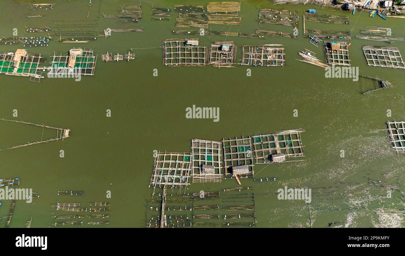 Fish farm on the river and a village with fishermen. Hinigaran River ...