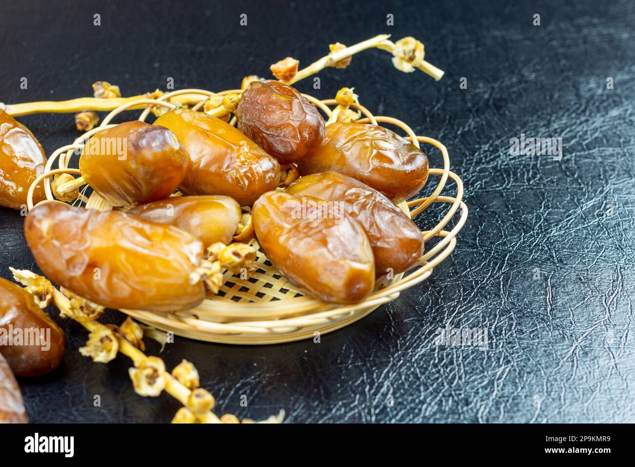 Close-up of Algerian royal dates on a wooden plate on a black ...