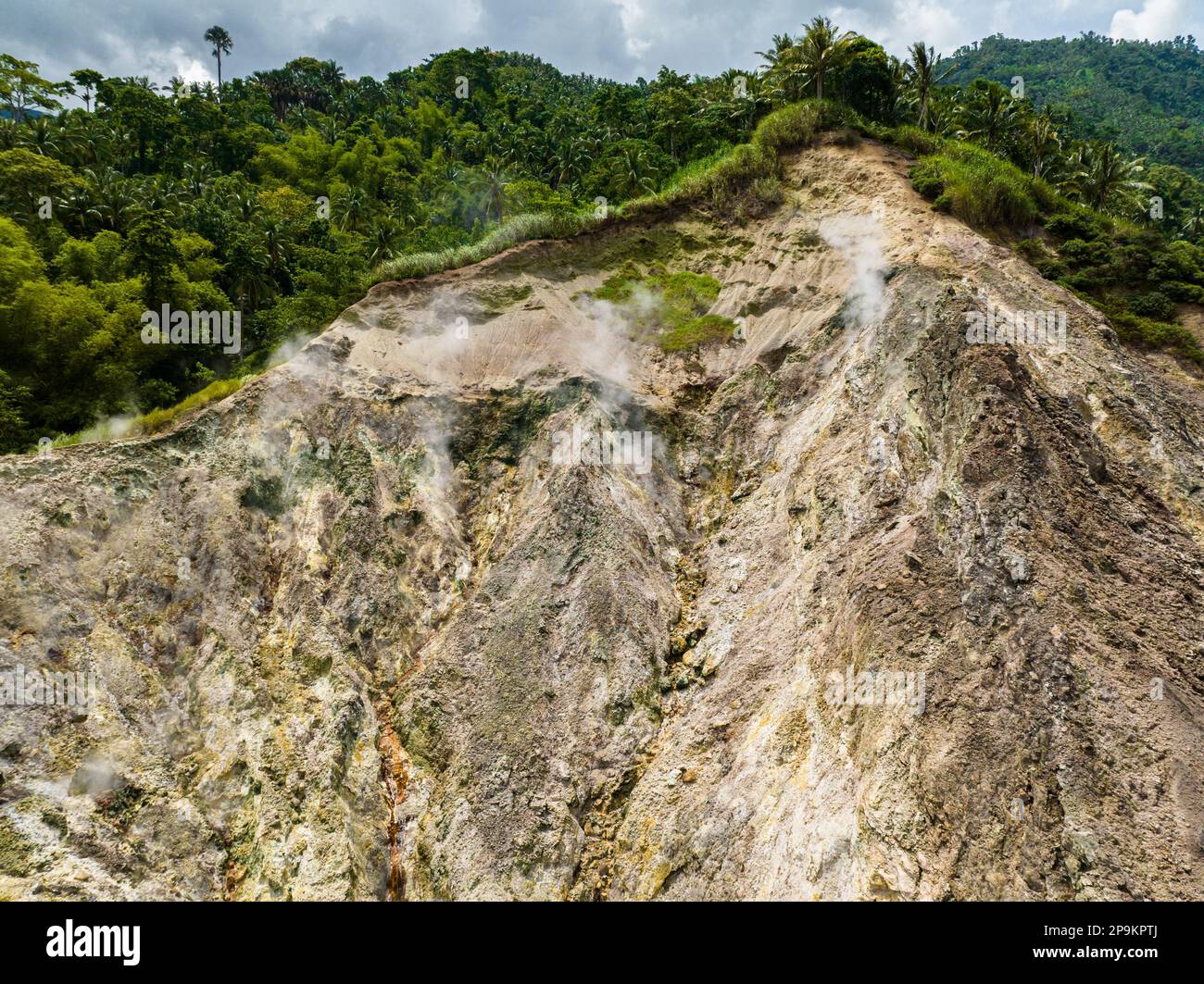 Aerial view of volcanic activity on a mountainside with smoke and ...