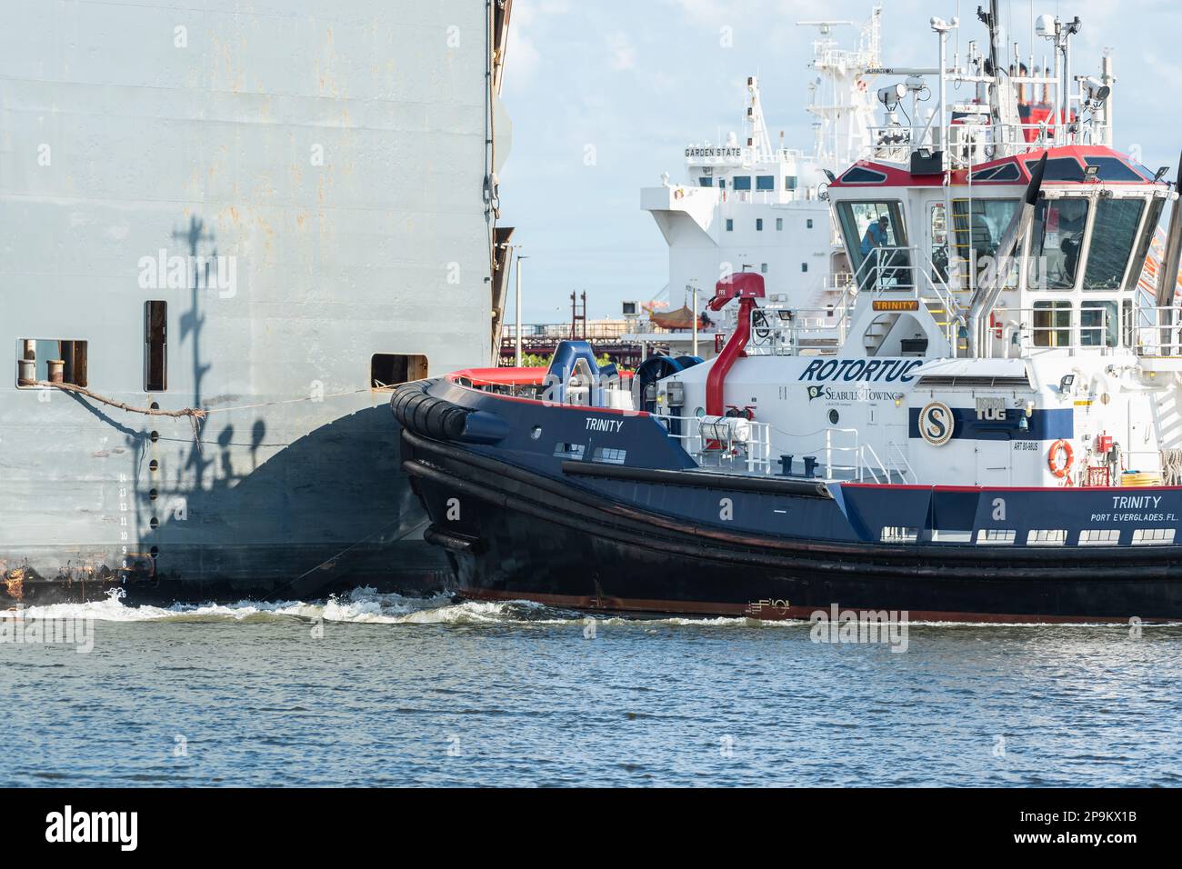 Pusher tug maneuvering barge Stock Photo - Alamy