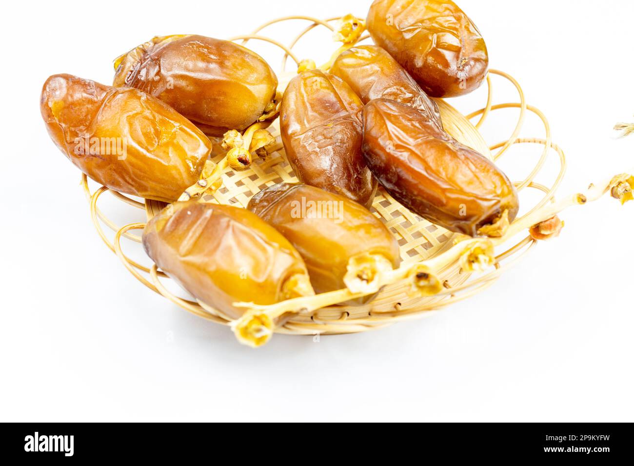 Close-up of Algerian royal dates on a wooden plate on a white ...