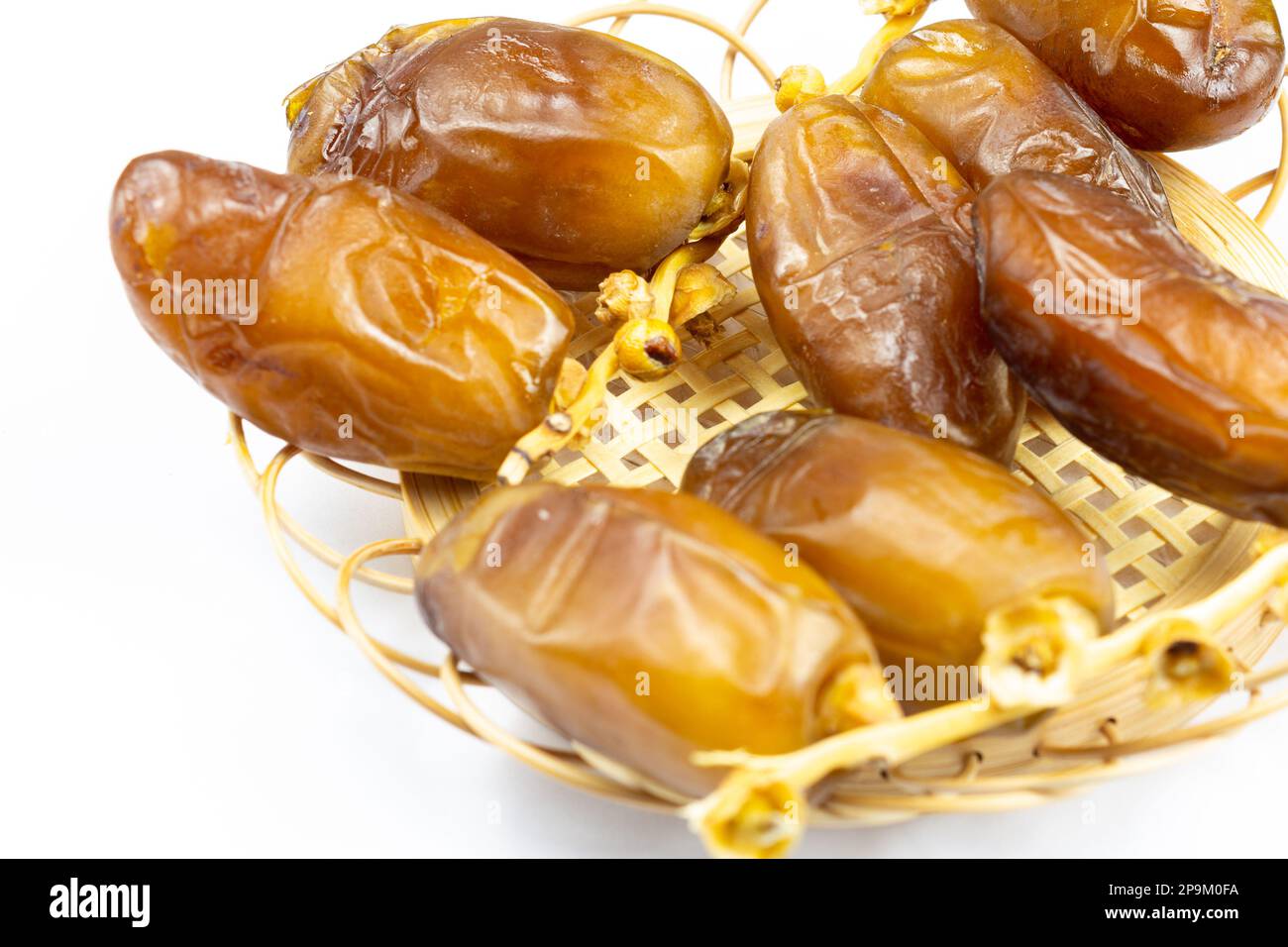 Close-up of Algerian royal dates on a wooden plate on a white ...