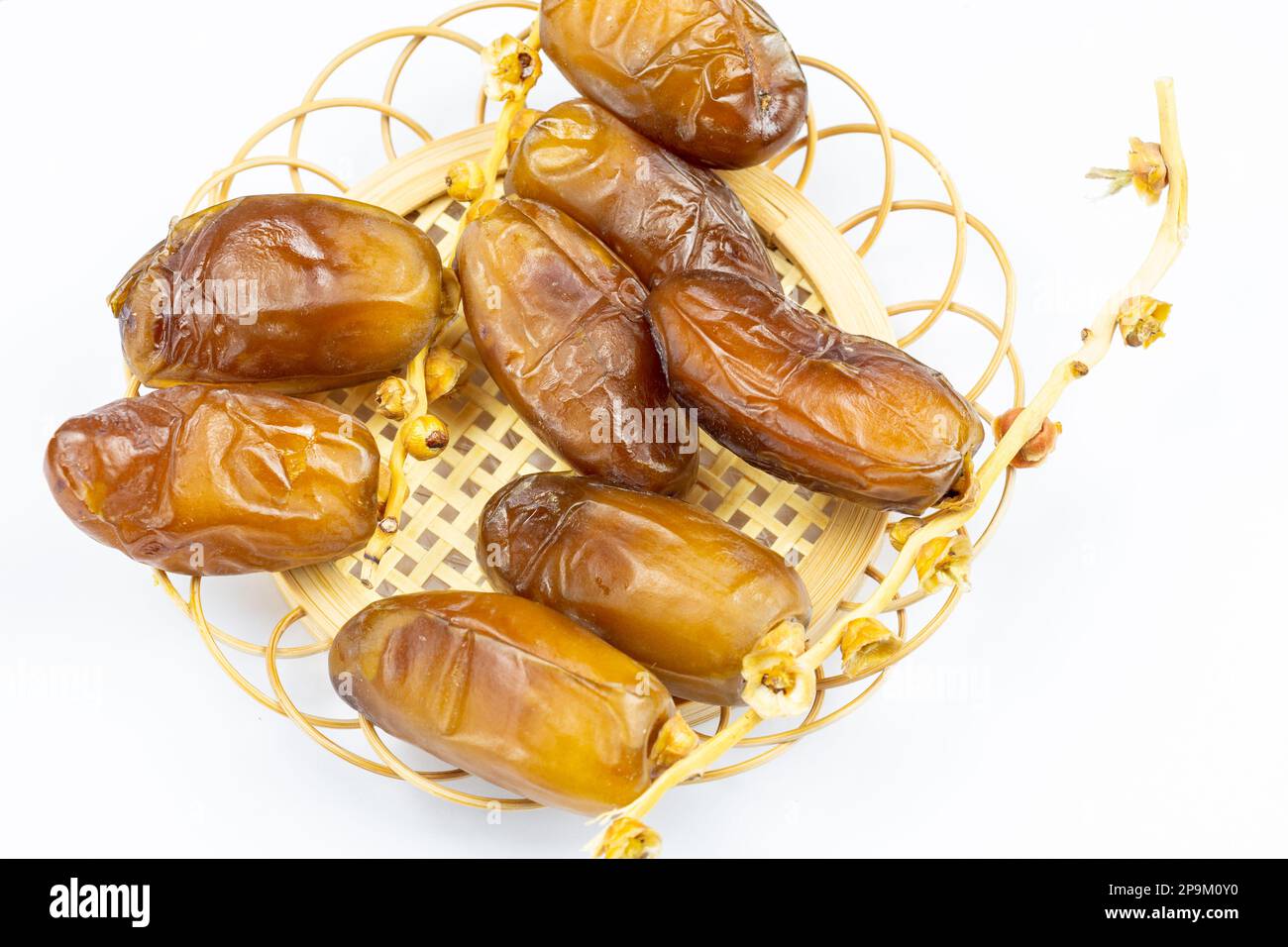 Close-up of Algerian royal dates on a wooden plate on a white ...