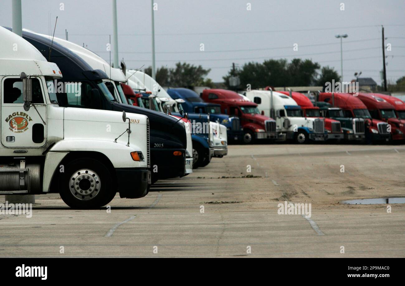 Trucks wait at a staging area to deliver supplies to residents affected ...