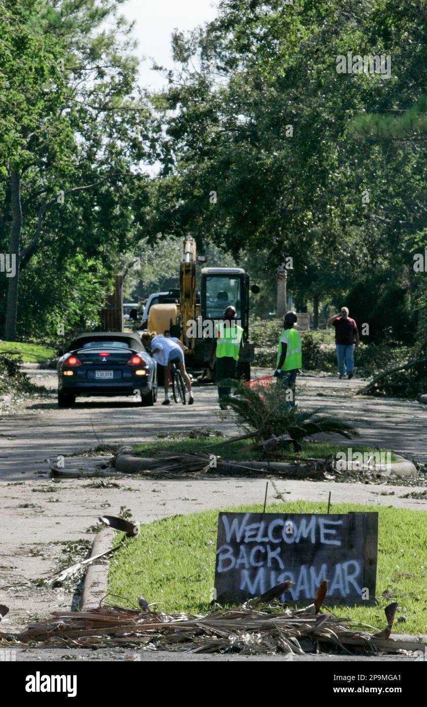 Recovery crews work near a sign welcoming residents back to the Miramar ...