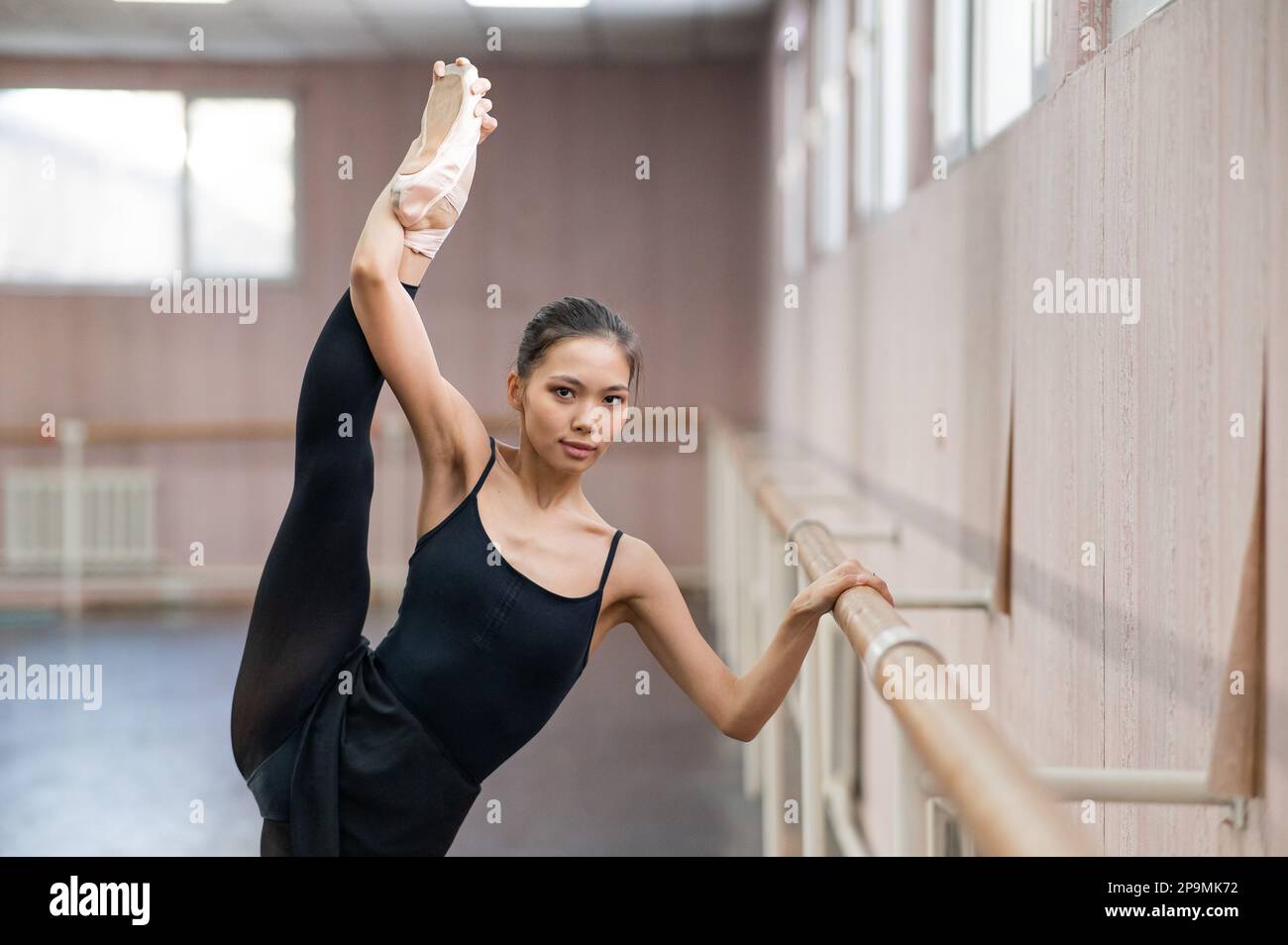 Asian woman doing splits at the ballet barre Stock Photo - Alamy