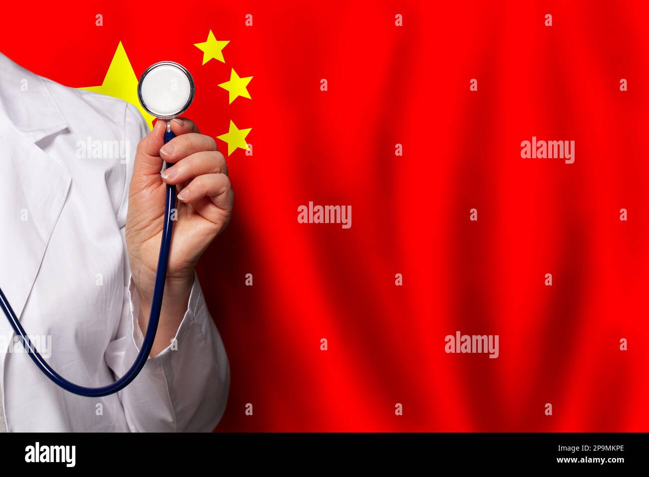 Chinese doctor's hand with stethoscope on the background of flag of ...