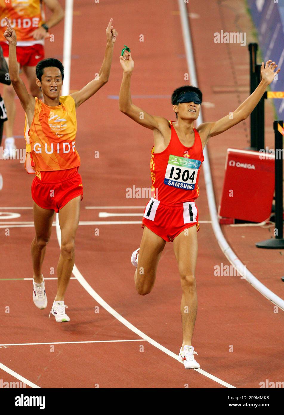 Zhang Zhen, right, and his guide celebrate after crossing the finish ...