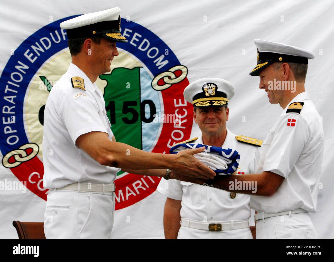 Canadian Commodore Bob Davidson, left, hands a command flag to Danish ...