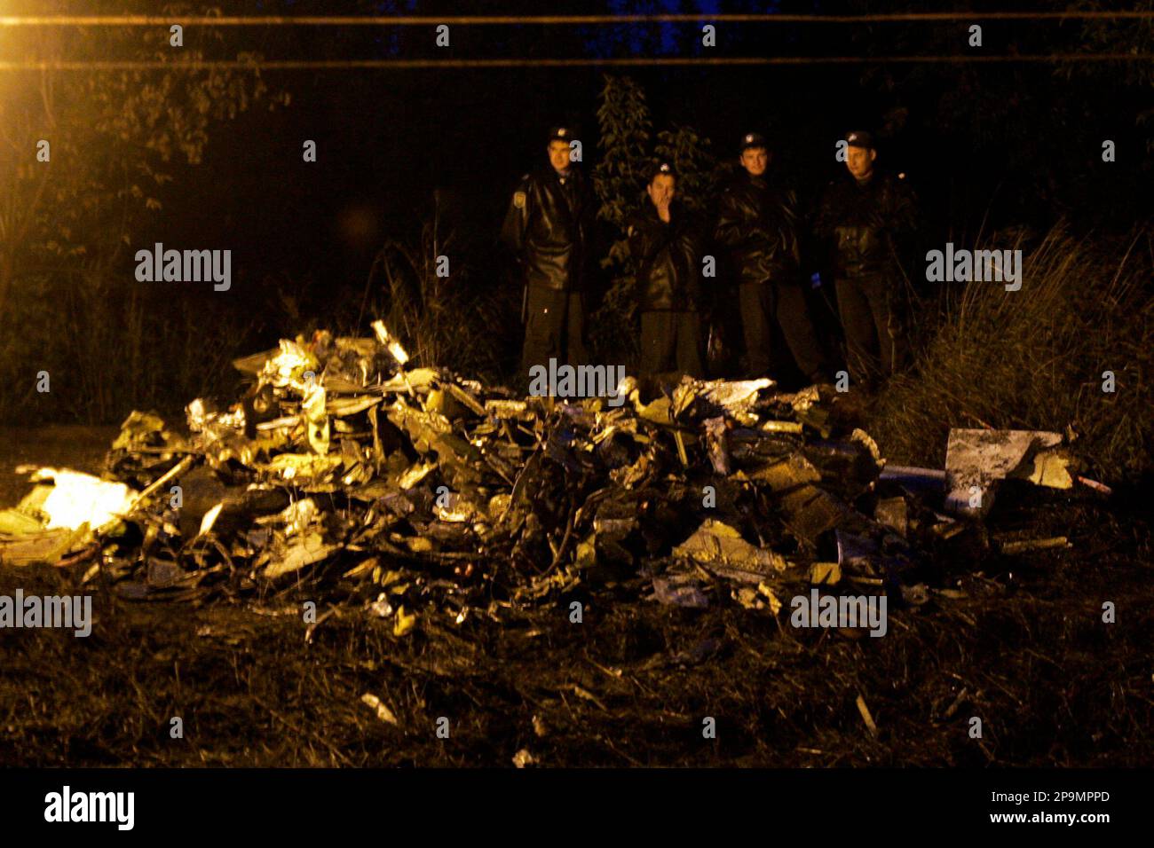 Police officers look at the debris of a Boeing-737-500 scattered around ...