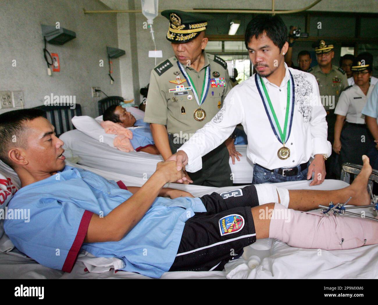 Filipino boxing champion Manny Pacquiao, right, shakes hands with ...